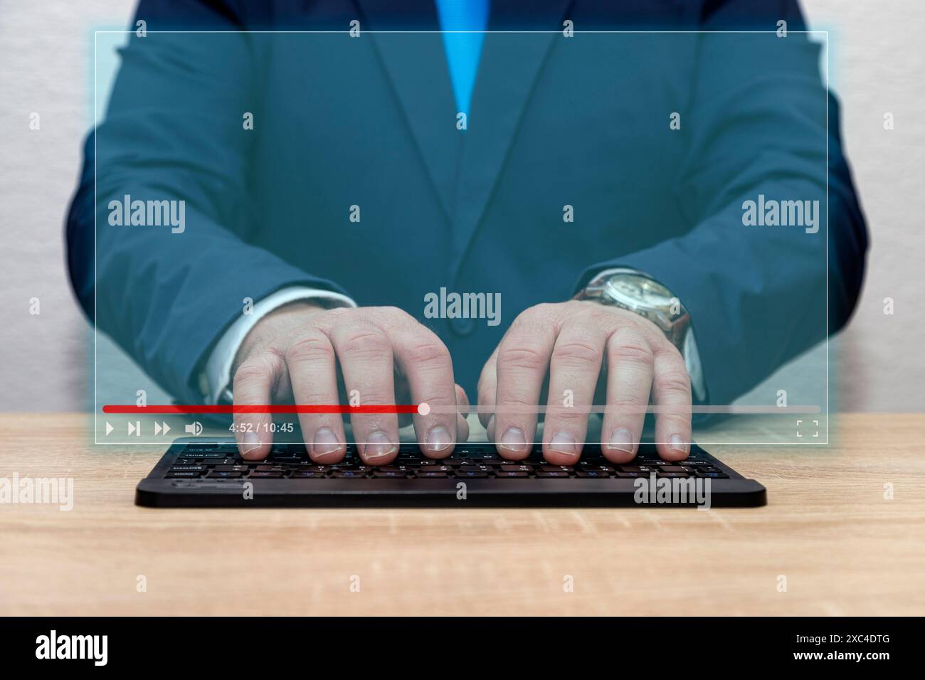 An unrecognizable man in a suit is typing on a keyboard with video ...