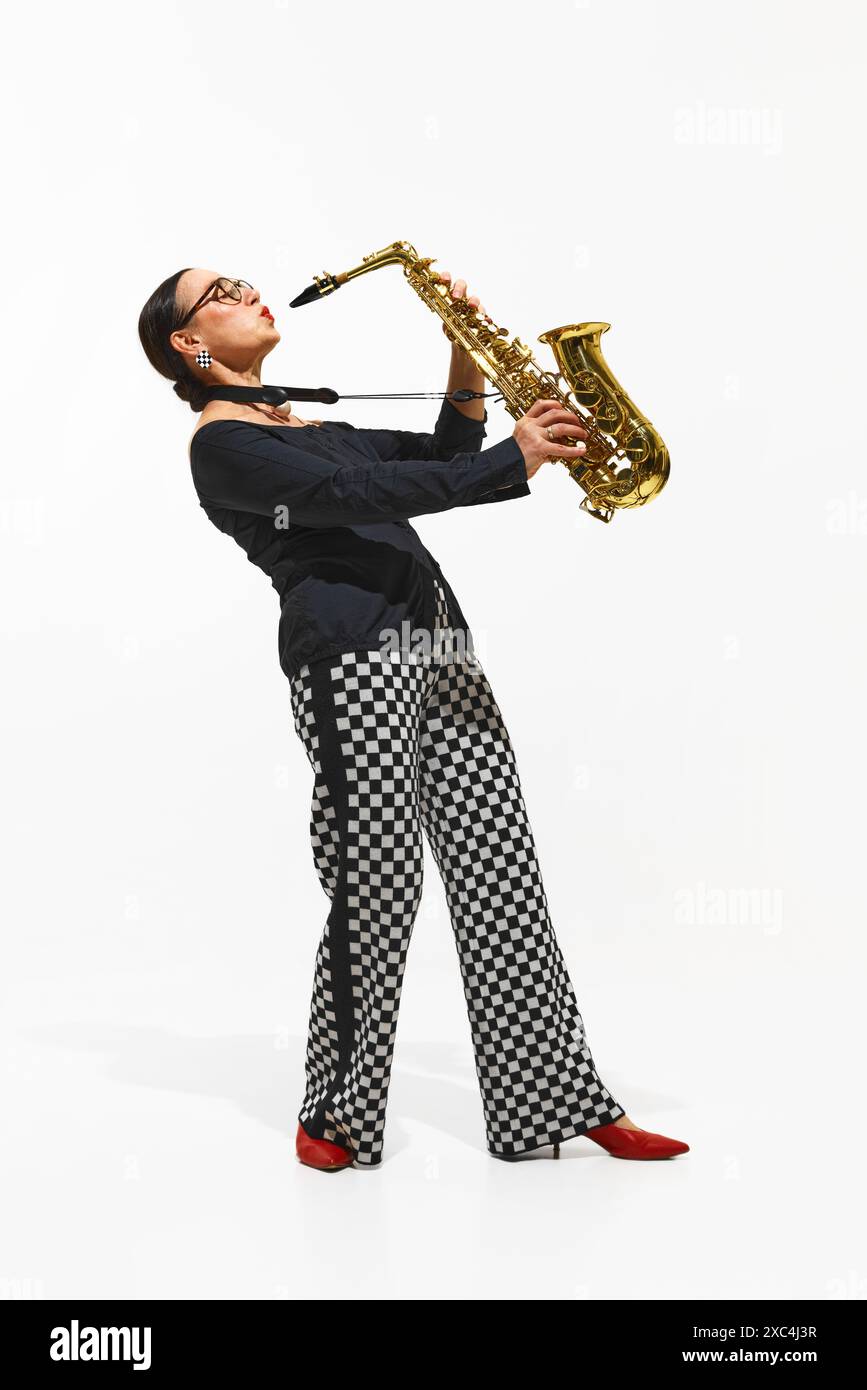 Stylish woman, musician in visually striking outfit plays the saxophone ...