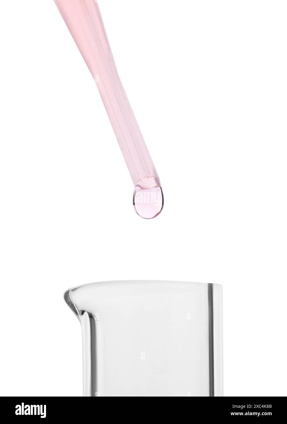 Dripping liquid from pipette into beaker on white background, closeup ...