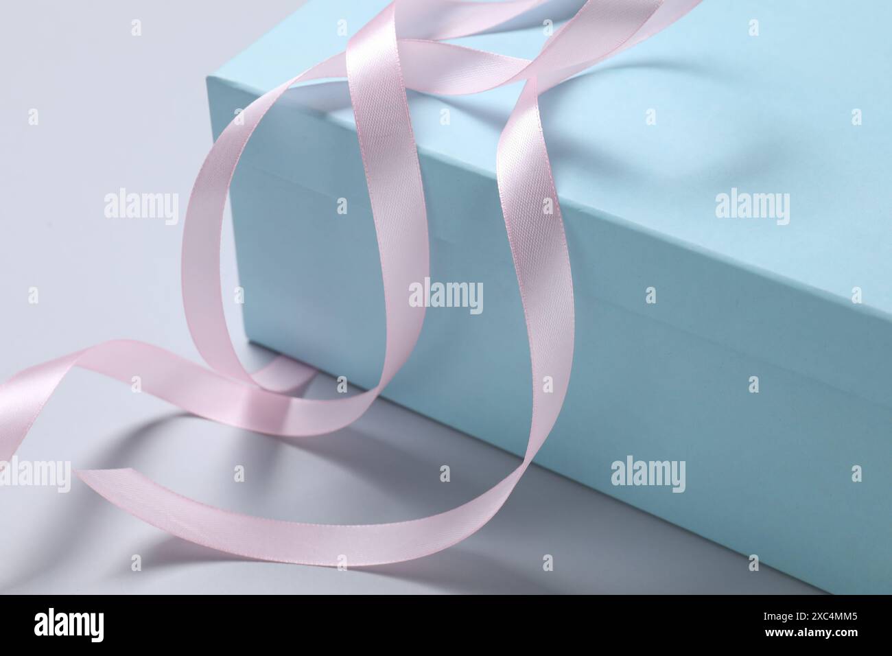 Beautiful pink ribbon and gift box on white background Stock Photo - Alamy