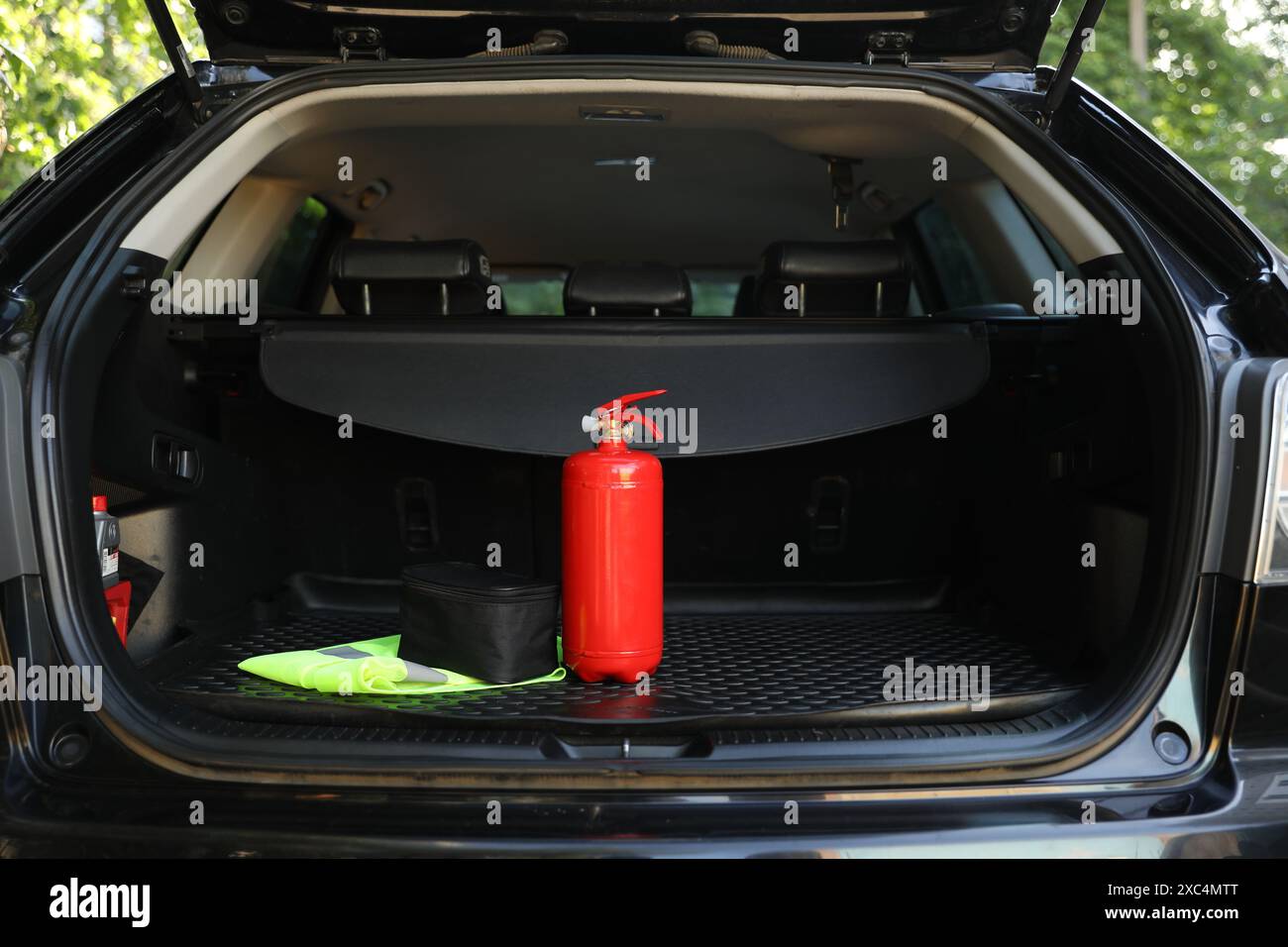 Red fire extinguisher in trunk. Car safety equipment Stock Photo - Alamy