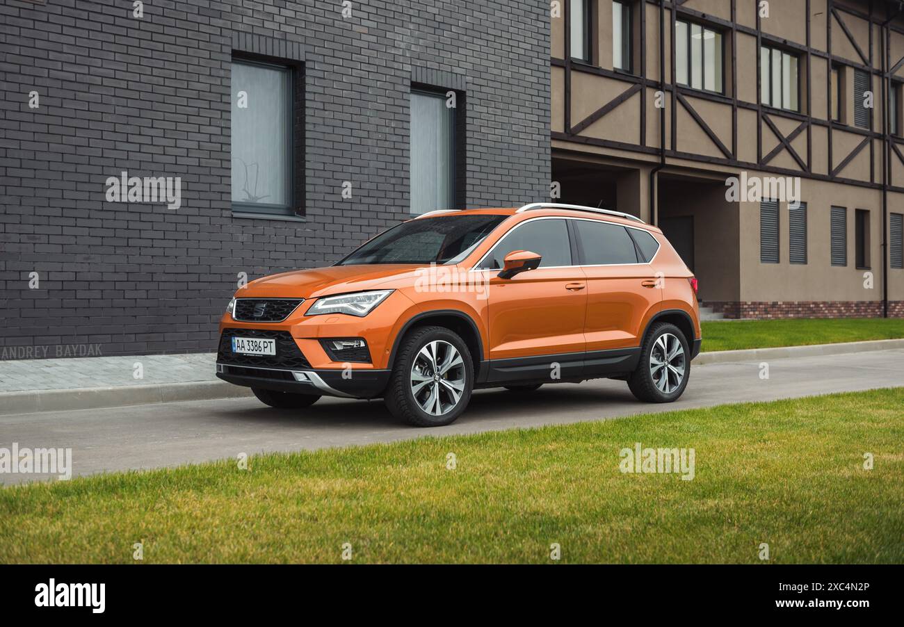 Samoa Orange SEAT Ateca parked near modern brick building. Three ...