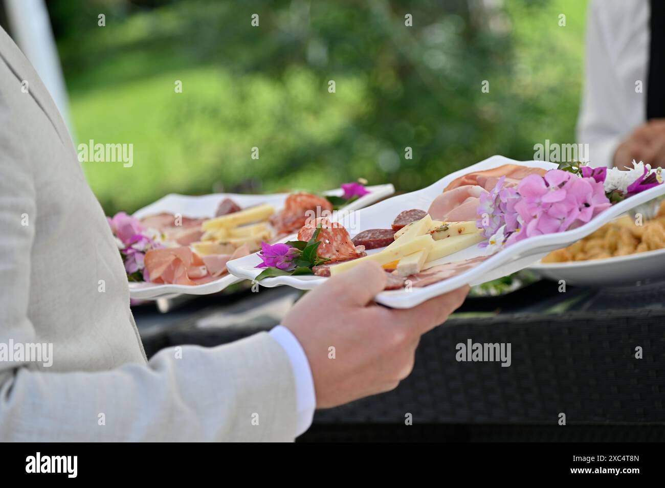 Waiter holding two plates for the bride and groom at the Italian ...