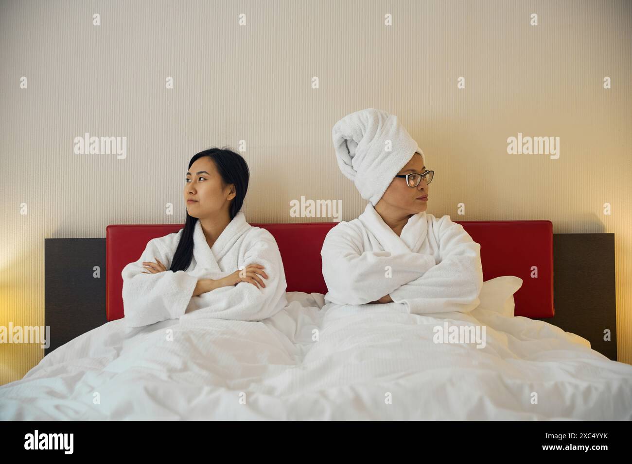 Mother and daughter ignoring each other after quarrel in bedroom Stock Photo - Alamy