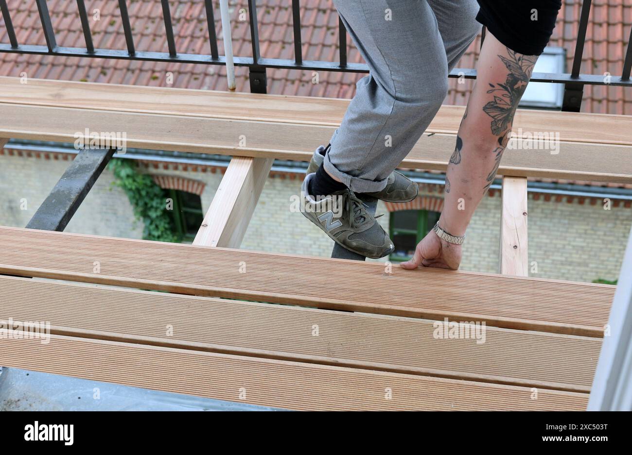 Berlin - Deutschland. Ein Balkon wird mit Holzbohlen bestückt ...