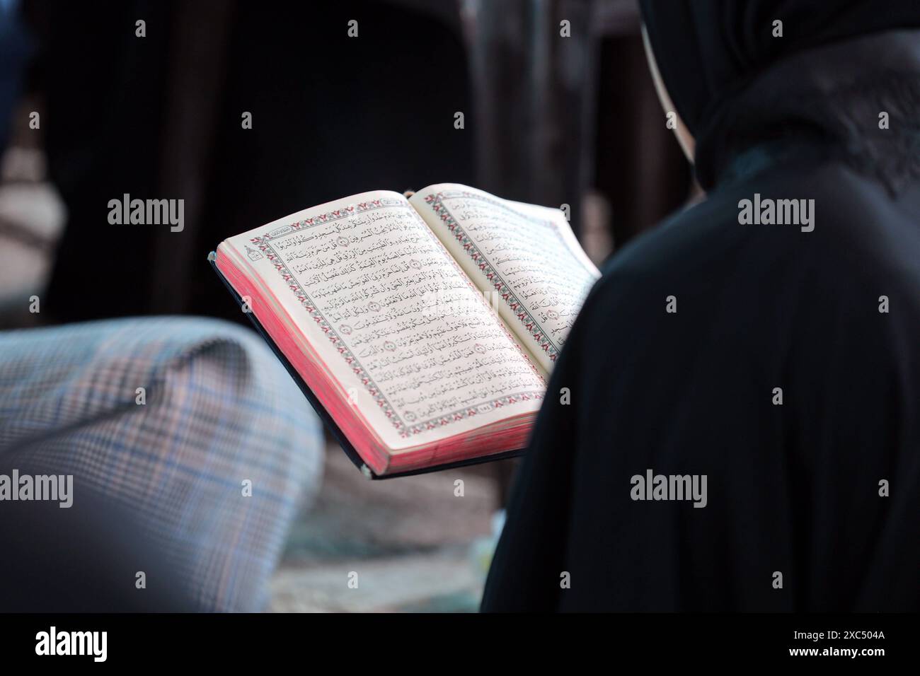 Women and girls assist each other to recite verses from the Koran ...