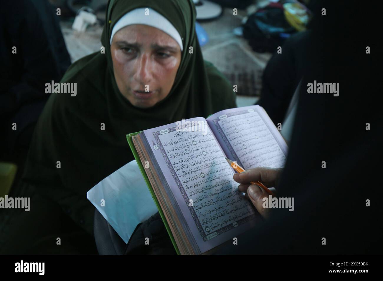 Women and girls assist each other to recite verses from the Koran ...