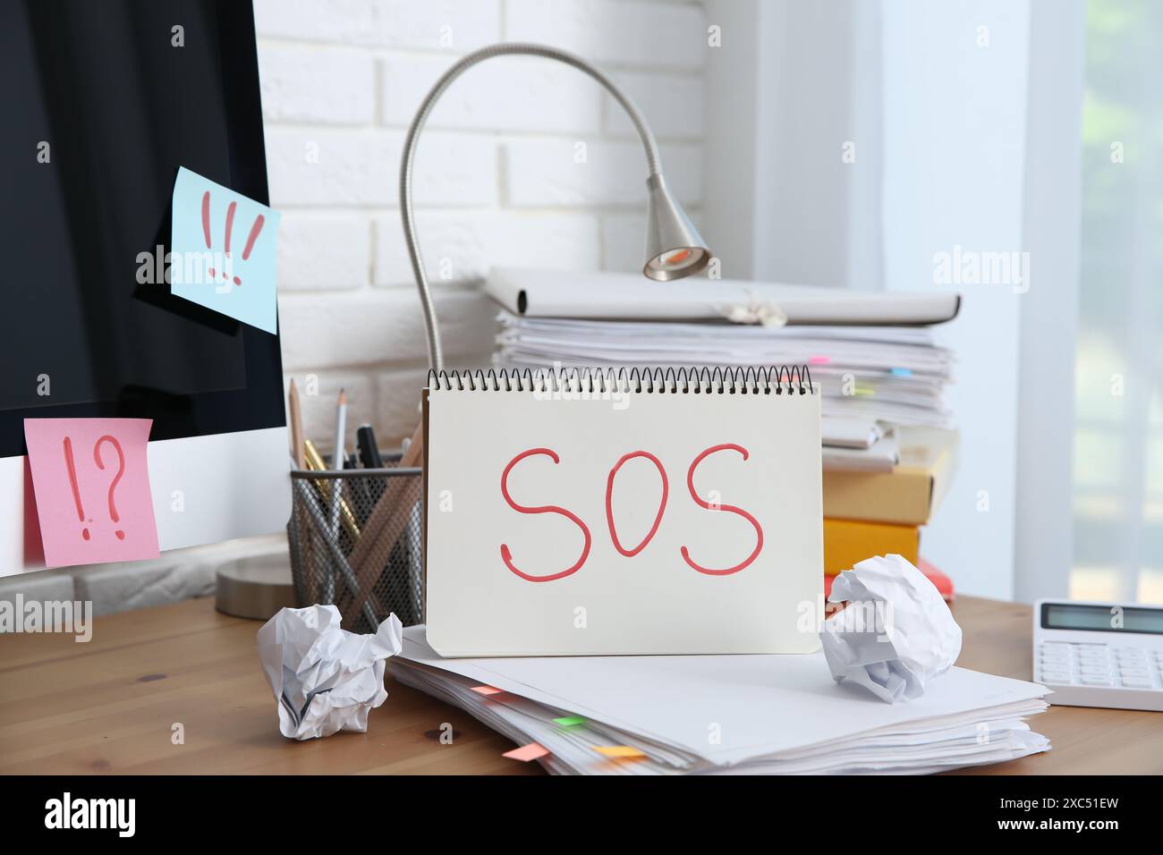 Notebook with word SOS and stationery on wooden table at workplace ...
