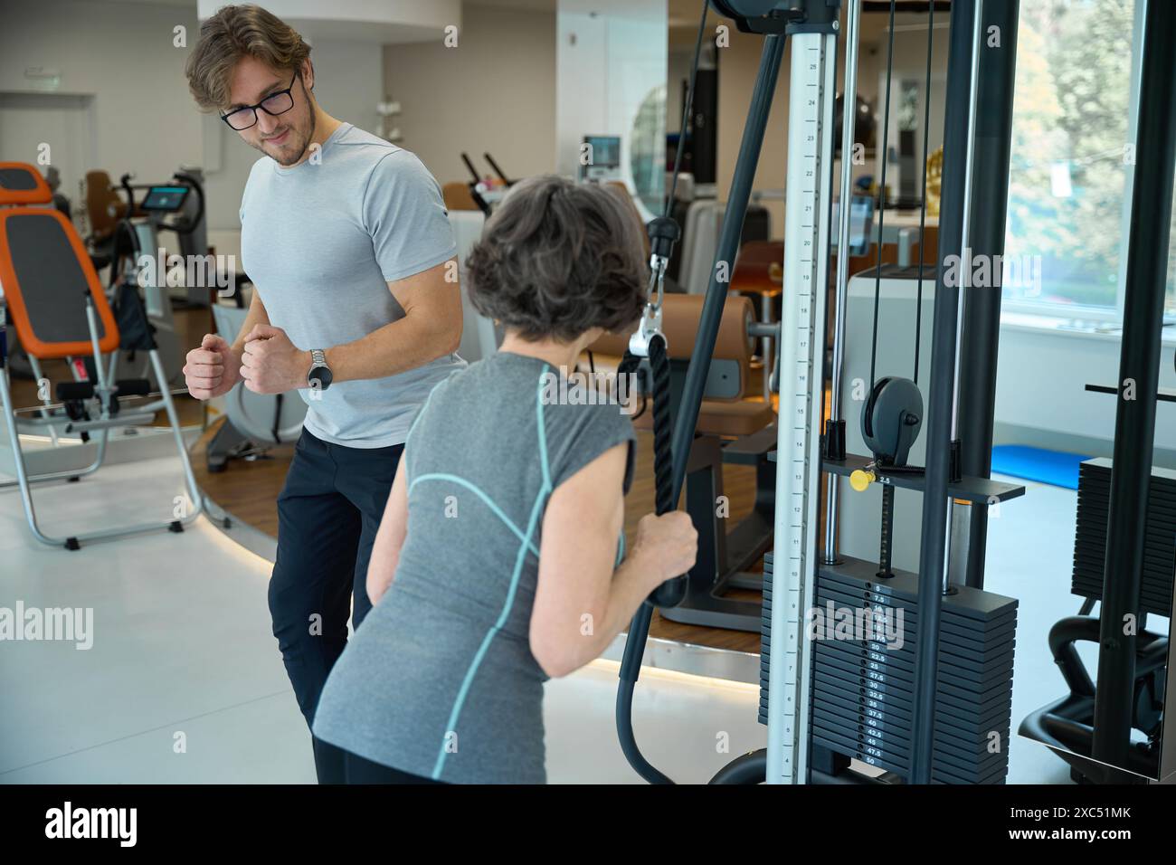 Elderly lady performs rehabilitation exercises on a block simulator ...