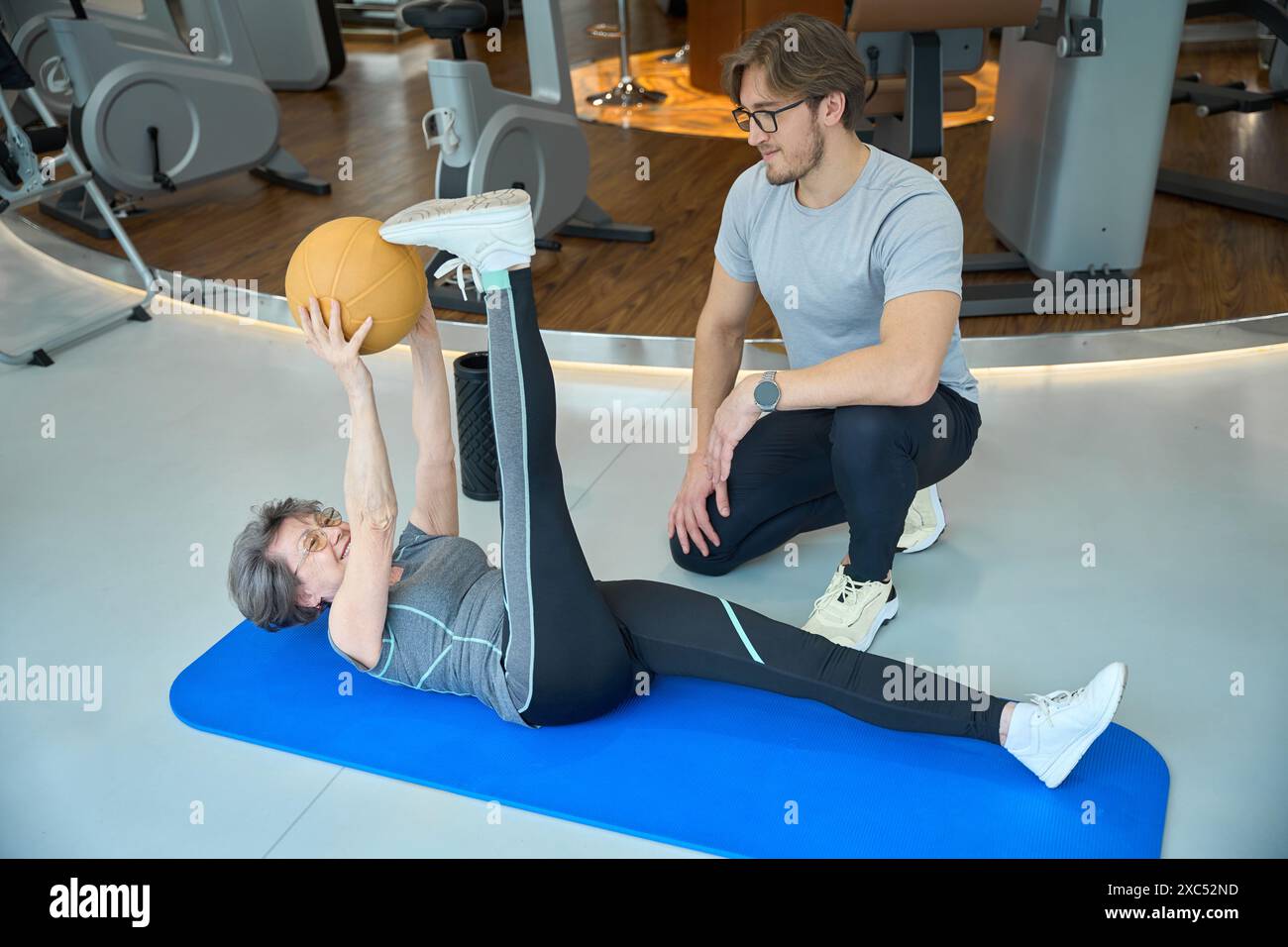 Elderly patient performs exercises with a ball in a gym Stock Photo - Alamy