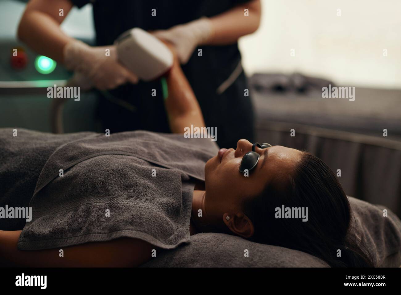 Young woman visiting beauty salon for laser epilation procedure Stock ...