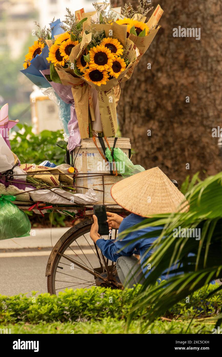 Traditional Hanoi Old Town flower entrepreneur, looking away from ...