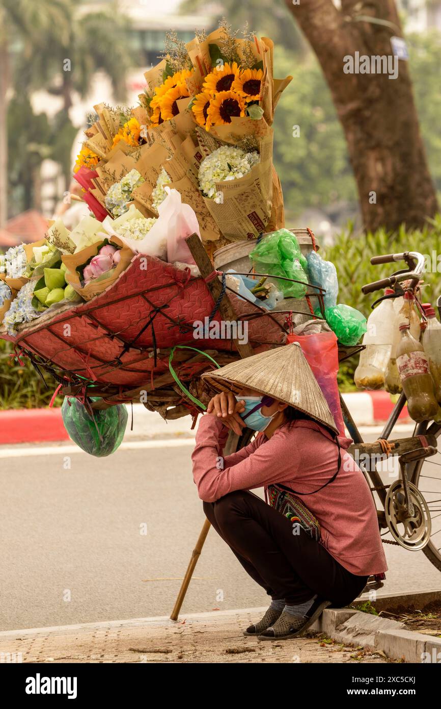 Traditional Hanoi Old Town flower entrepreneur, looking away from ...