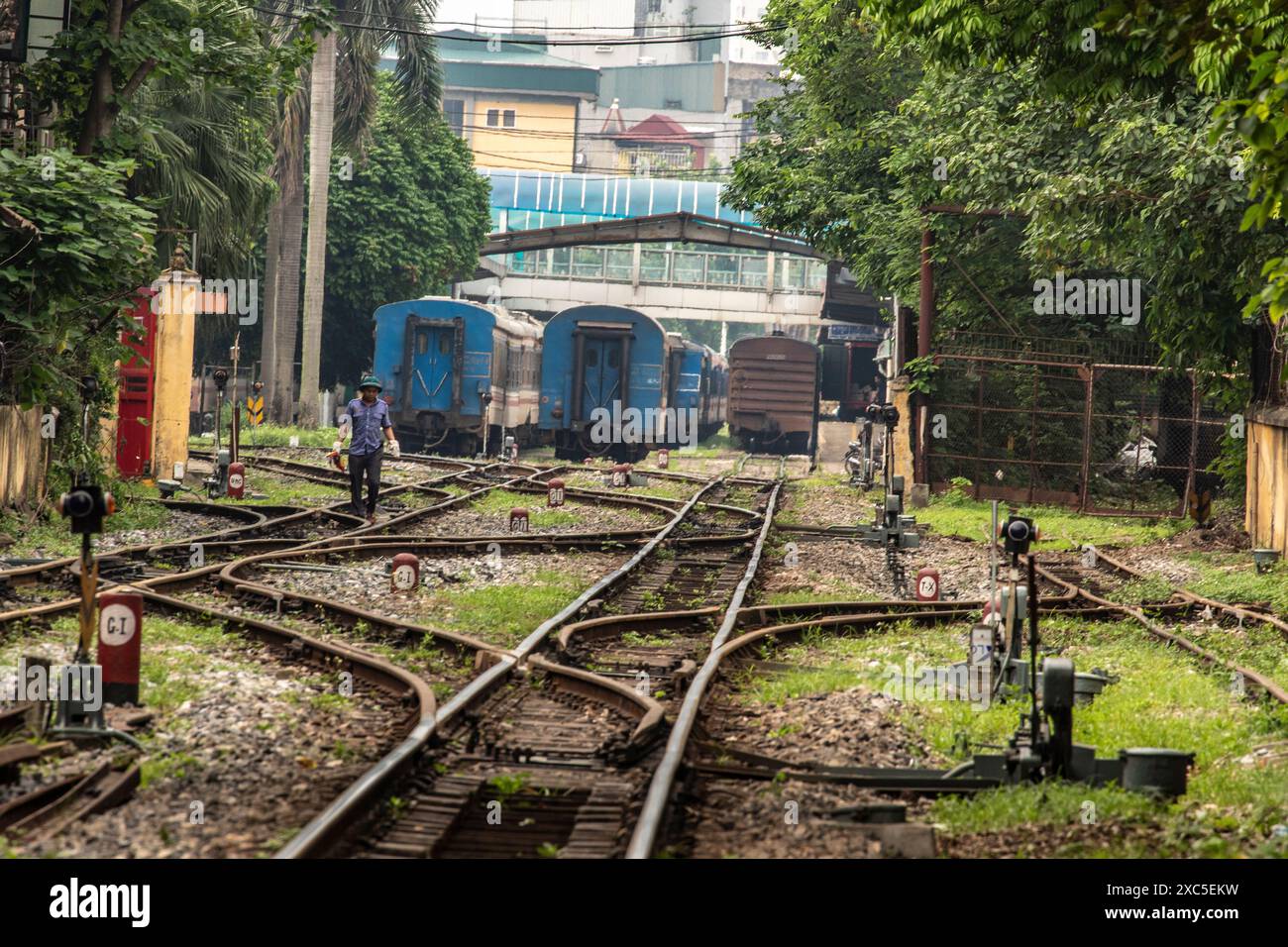 Rail track and blue Hanoi (Vietnam) 'Doorway Railway' train at rest ...