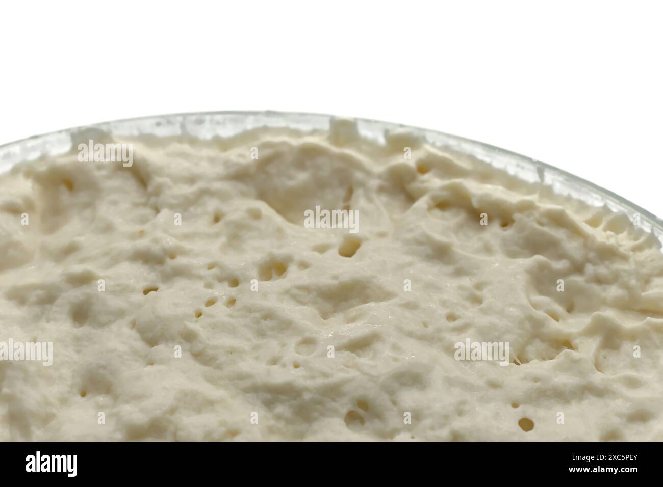 close up of fermented dough in glass bowl isolated white background ...