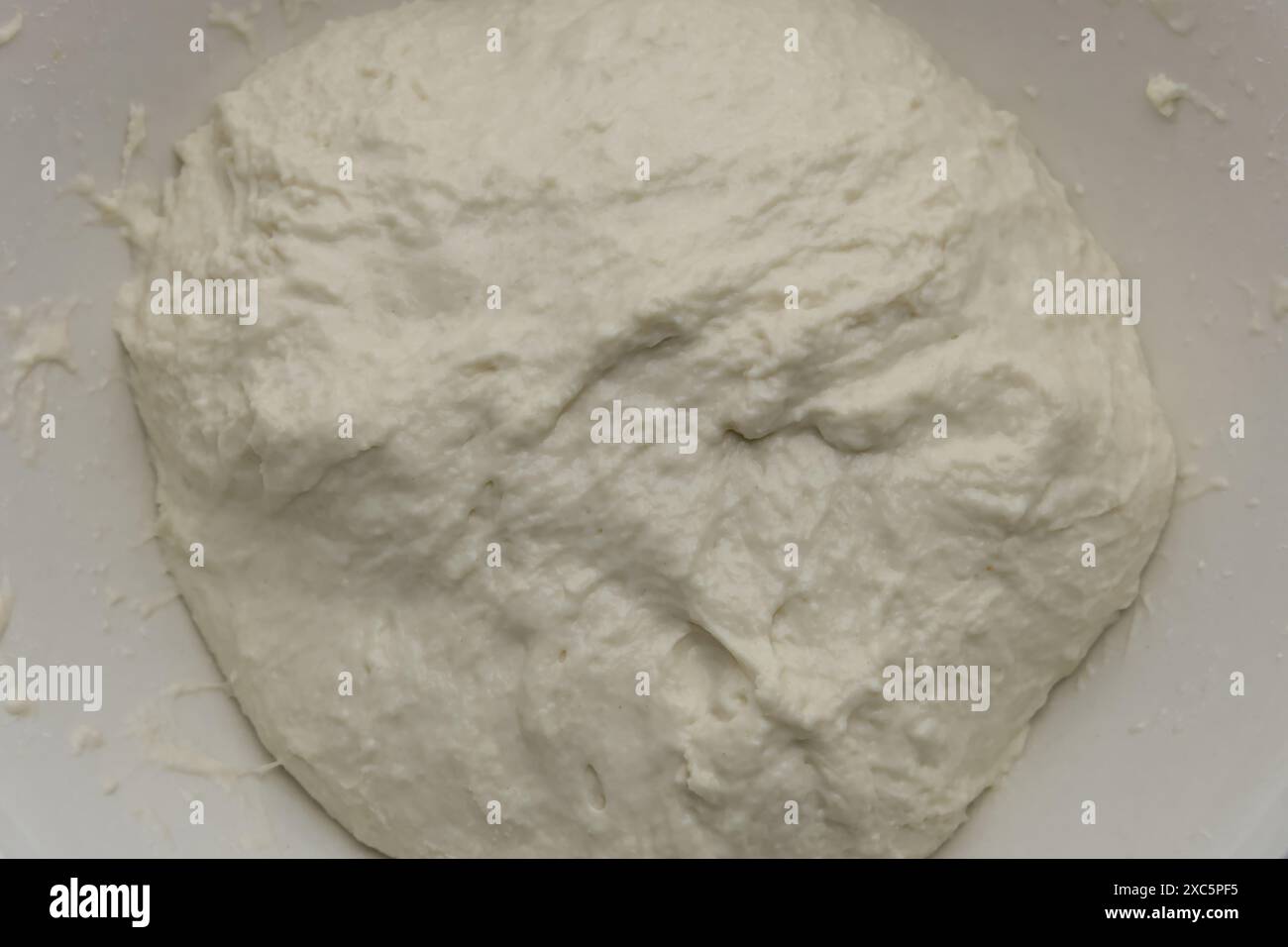 close up of fermented dough in glass bowl isolated white background ...