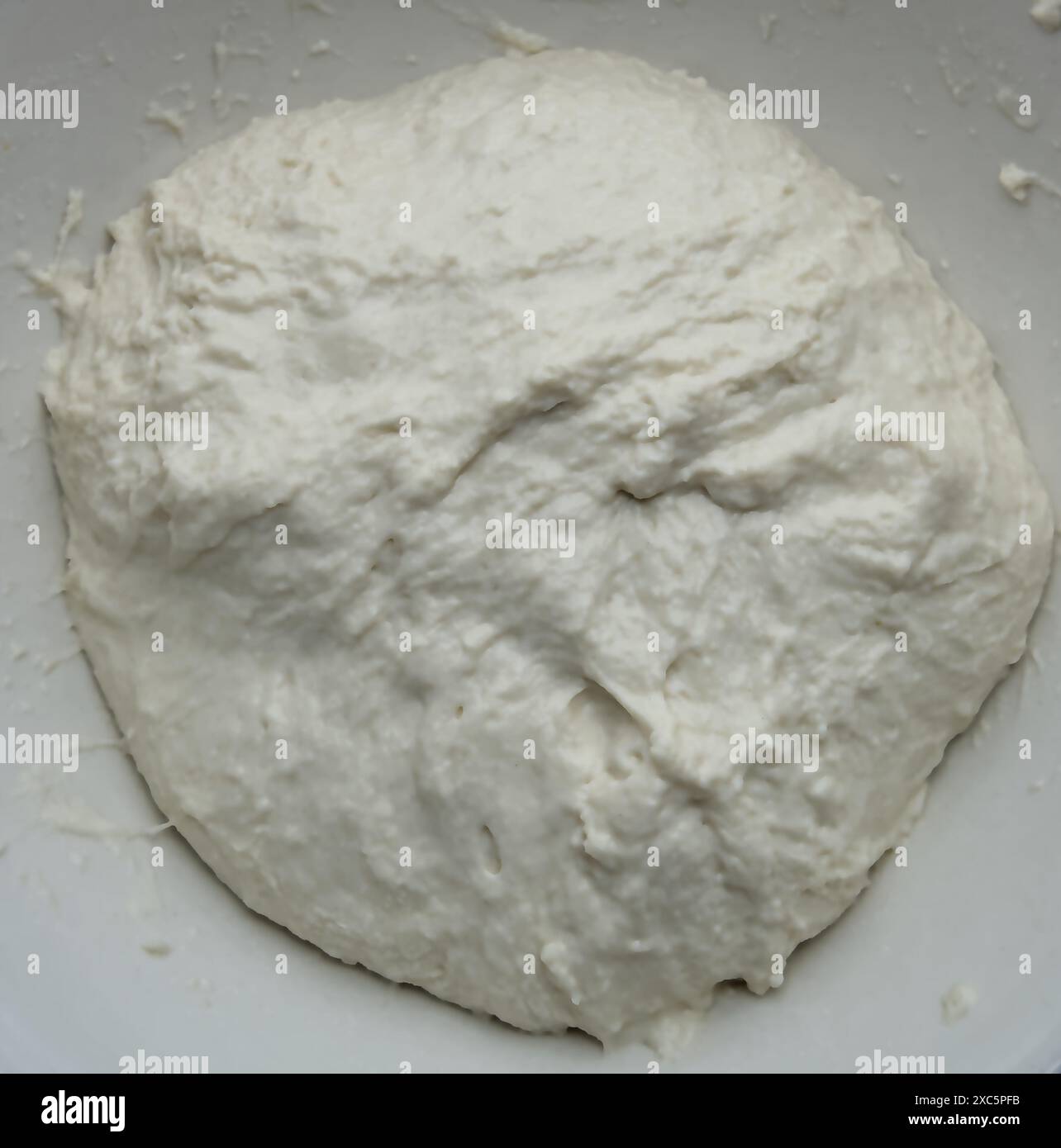 close up of fermented dough in glass bowl isolated white background ...