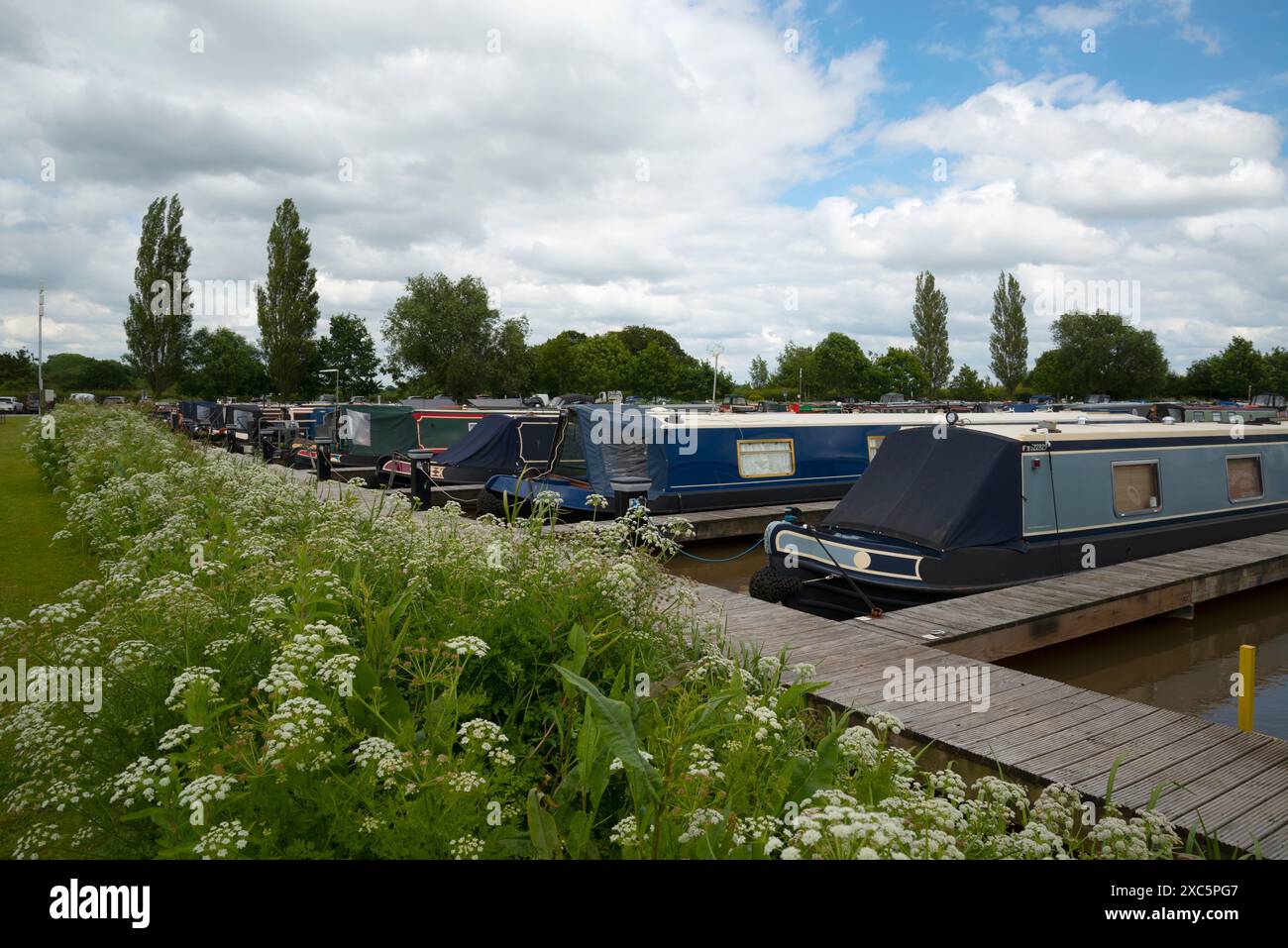 The jetty walkway and moored narrowboats in a popular marina in ...