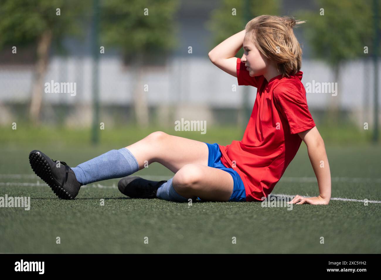Girl In Football Uniform Sits At Match On Football Field Stock Photo ...