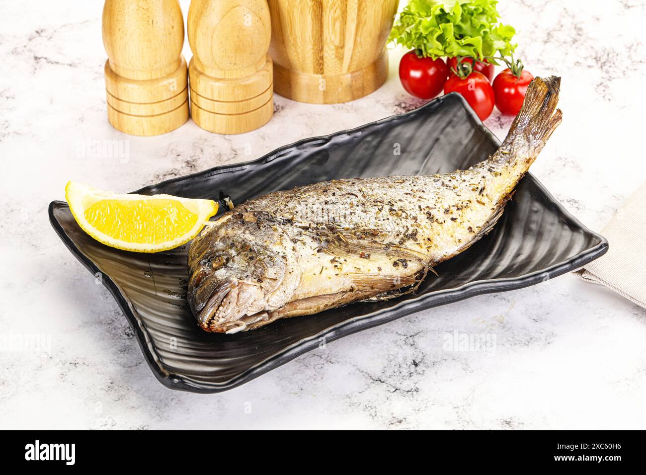 Baked Dorado fish served lemon slice Stock Photo - Alamy