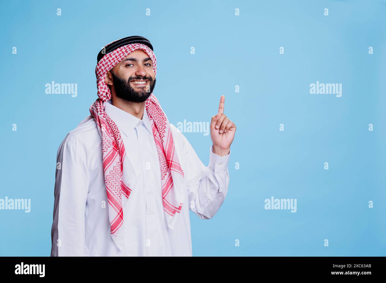 Smiling muslim man wearing traditional arabic clothes showcasing ...