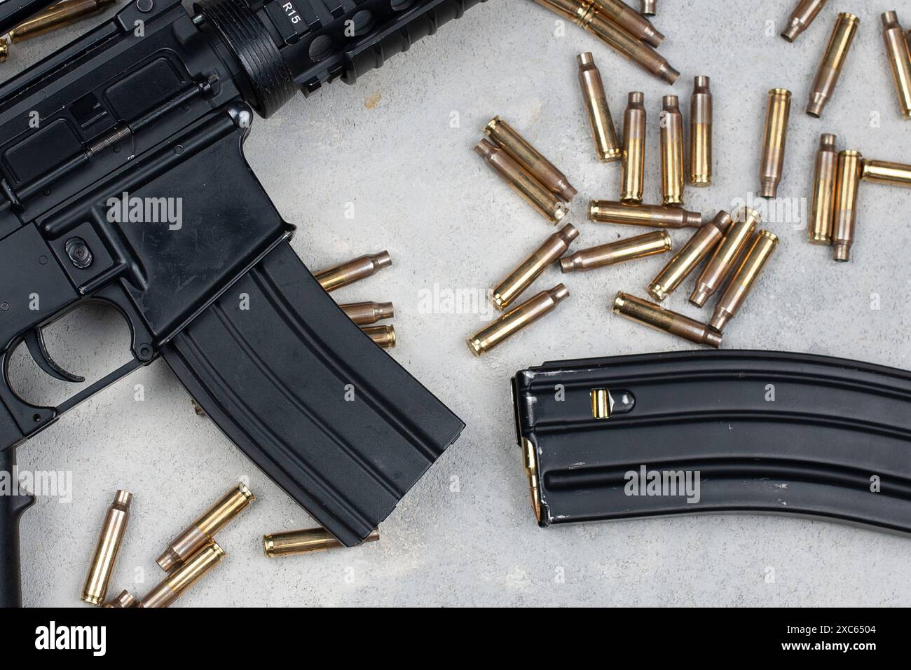 M4 carbine and 5.56mm shells and magazine with bullets on grey concrete ...
