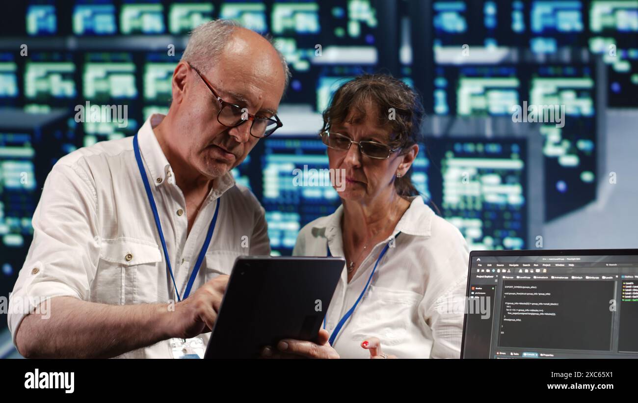 Tech savvy inspectors solving tasks on tablet while scripts are running on laptop terminal ...