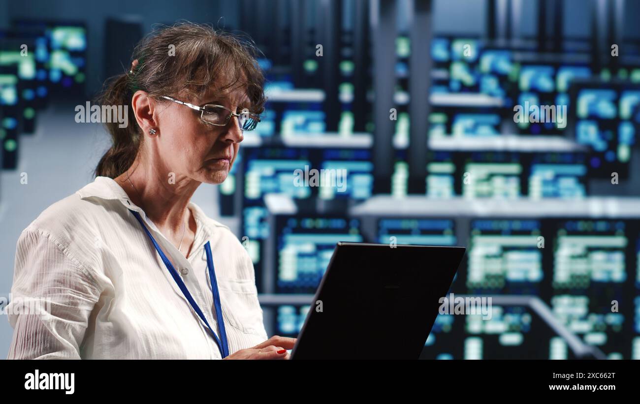 Elderly engineer in data center equipped to handle modern computing ...