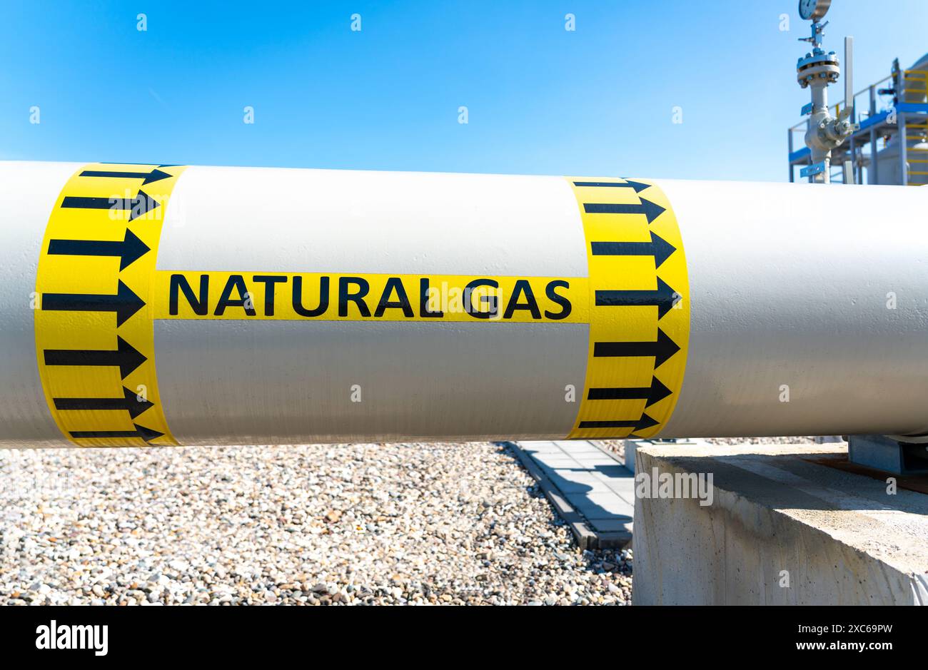 Natural gas pipeline with flow direction sign at compressor station ...