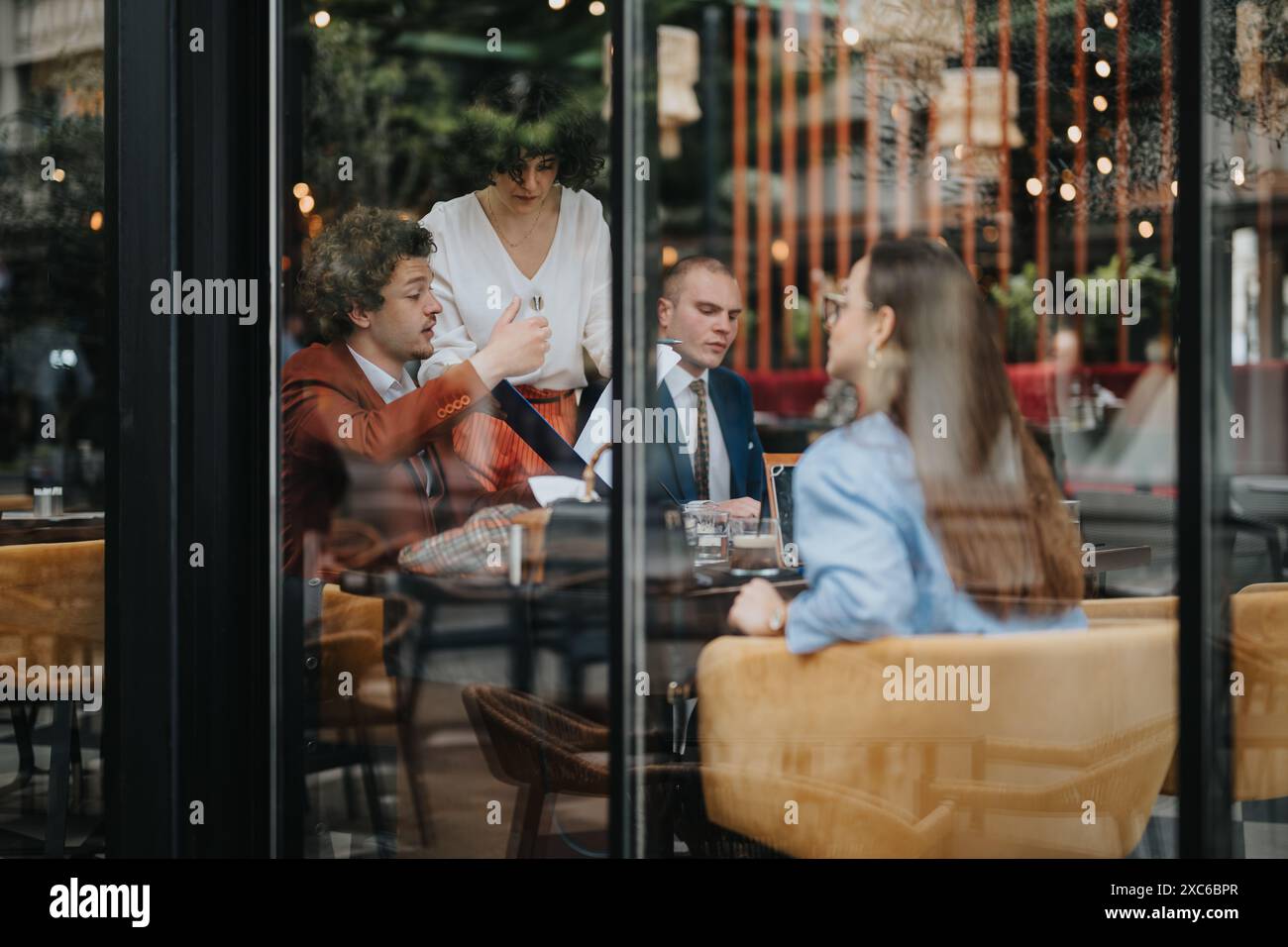 Business colleagues having a discussion in a modern cafe through glass ...