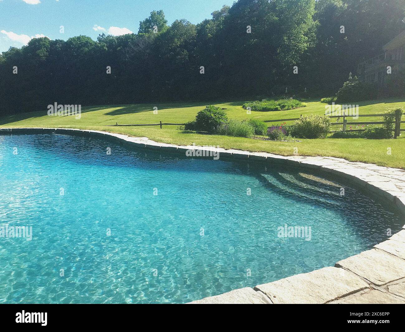Swimming pool surrounded by scenic landscape and gardens Stock Photo ...