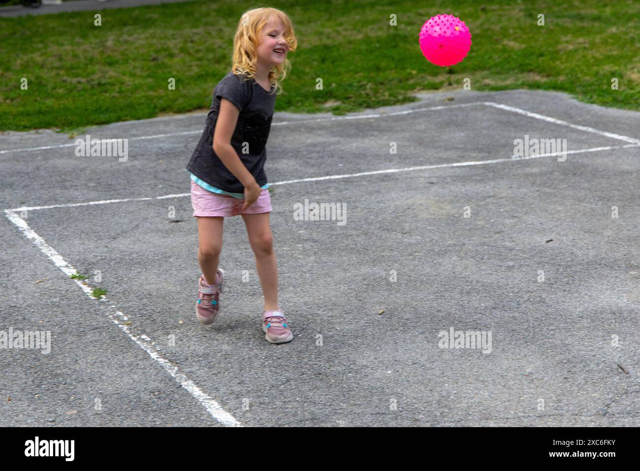 Young Girl Playing Catch With Pink Ball on Playground Stock Photo - Alamy