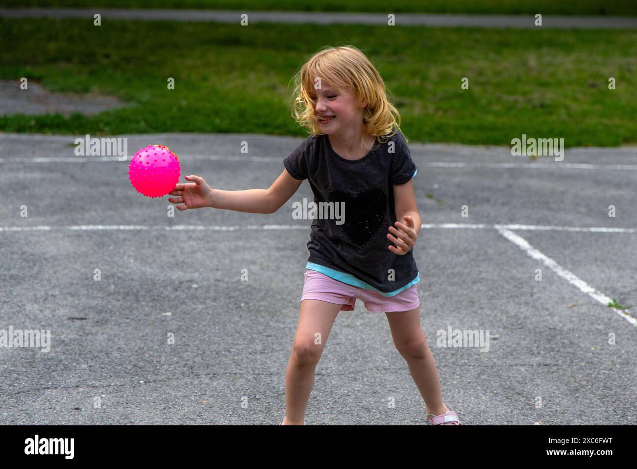Young Girl Playing With Pink Spiky Ball on Playground Stock Photo - Alamy