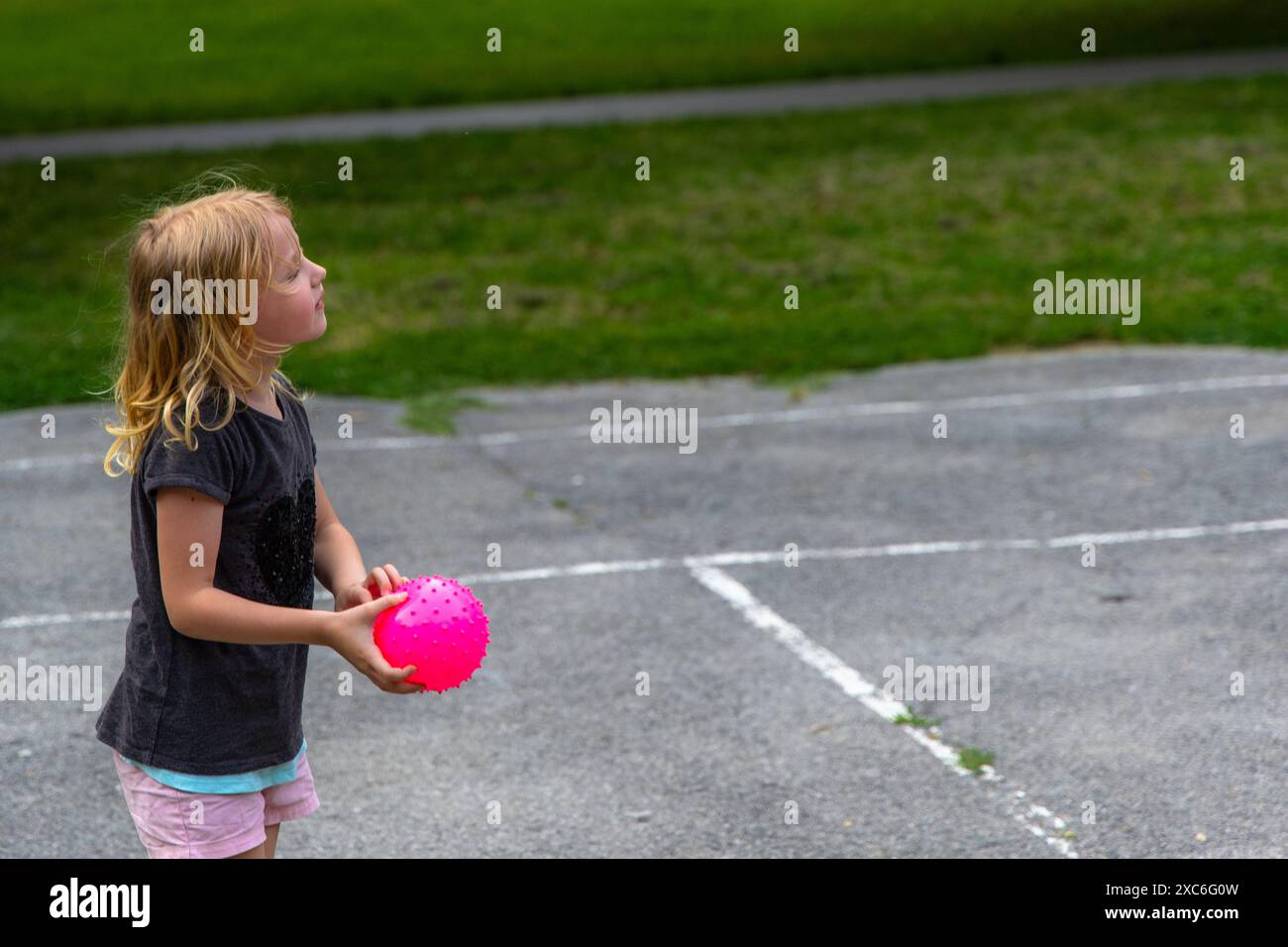 Young Girl Playing With a Pink Ball on a Playground Stock Photo - Alamy