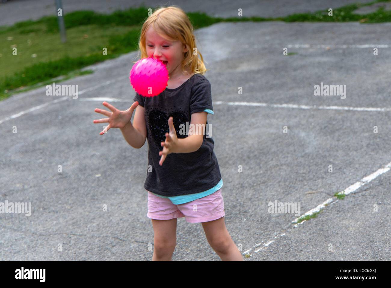 Young Girl Playing Catch With Pink Ball in Playground Stock Photo - Alamy