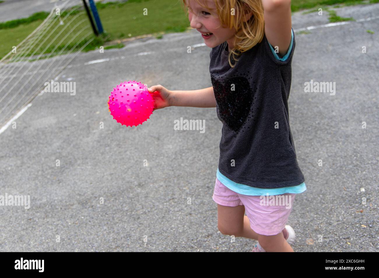 Young Girl Playing With A Pink Spiky Ball On A Playground Stock Photo ...