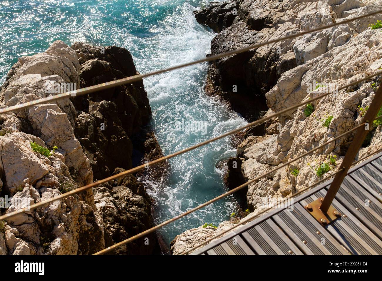 pedestrian bridge hanging over a cliff and ocean on French Riviera ...