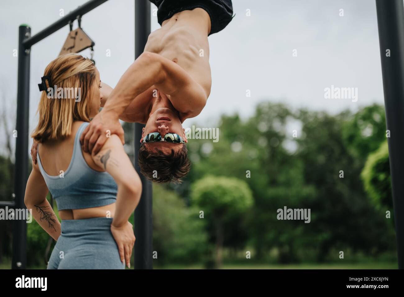 Outdoor calisthenics workout with a couple demonstrating strength ...