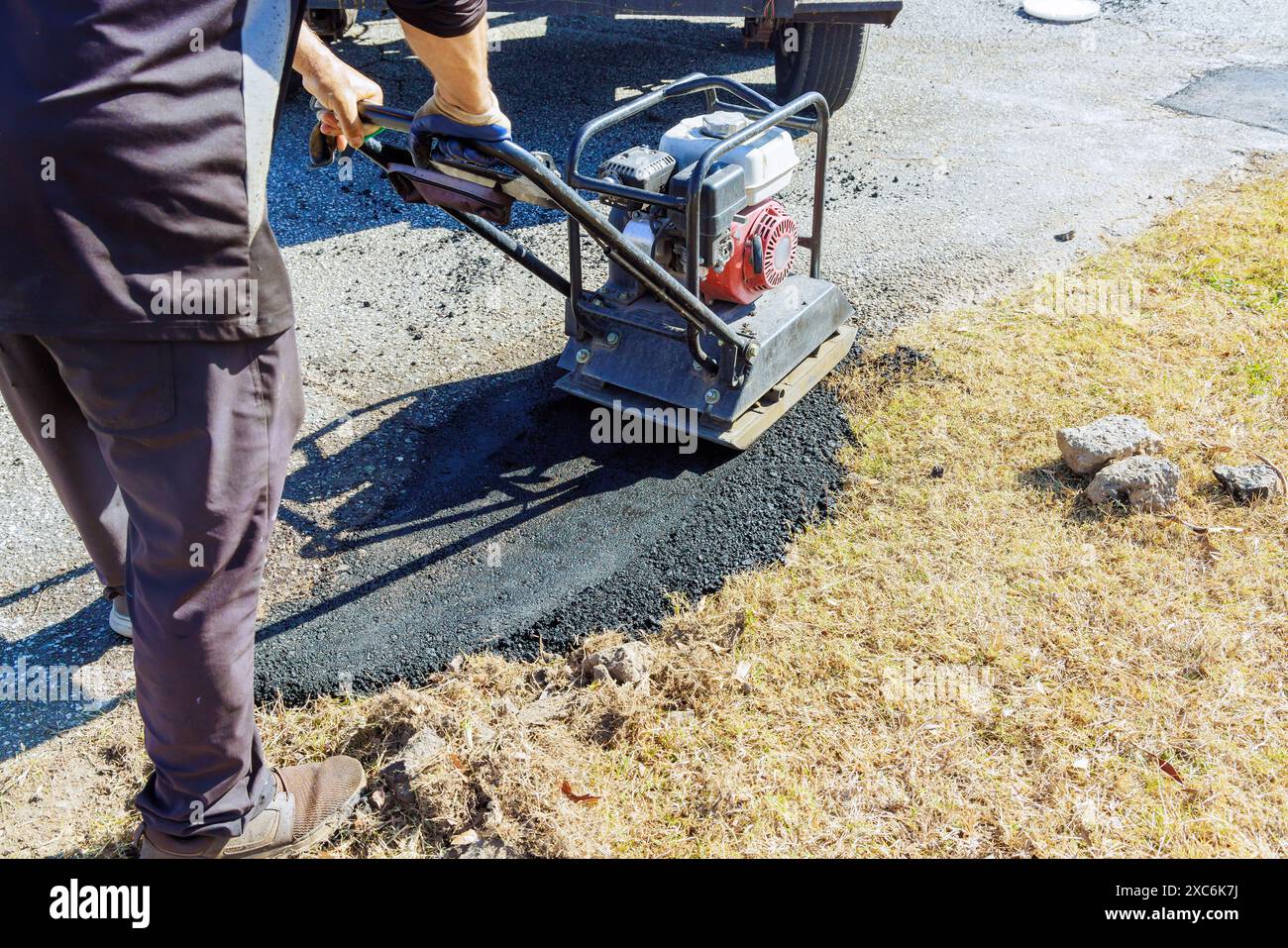 Manual tamping of asphalt using tamping compacting vibratory at parking ...