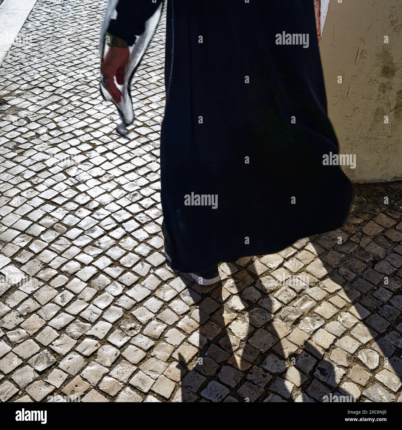 woman walks carefully on the charming but dangerously slippery pavement ...