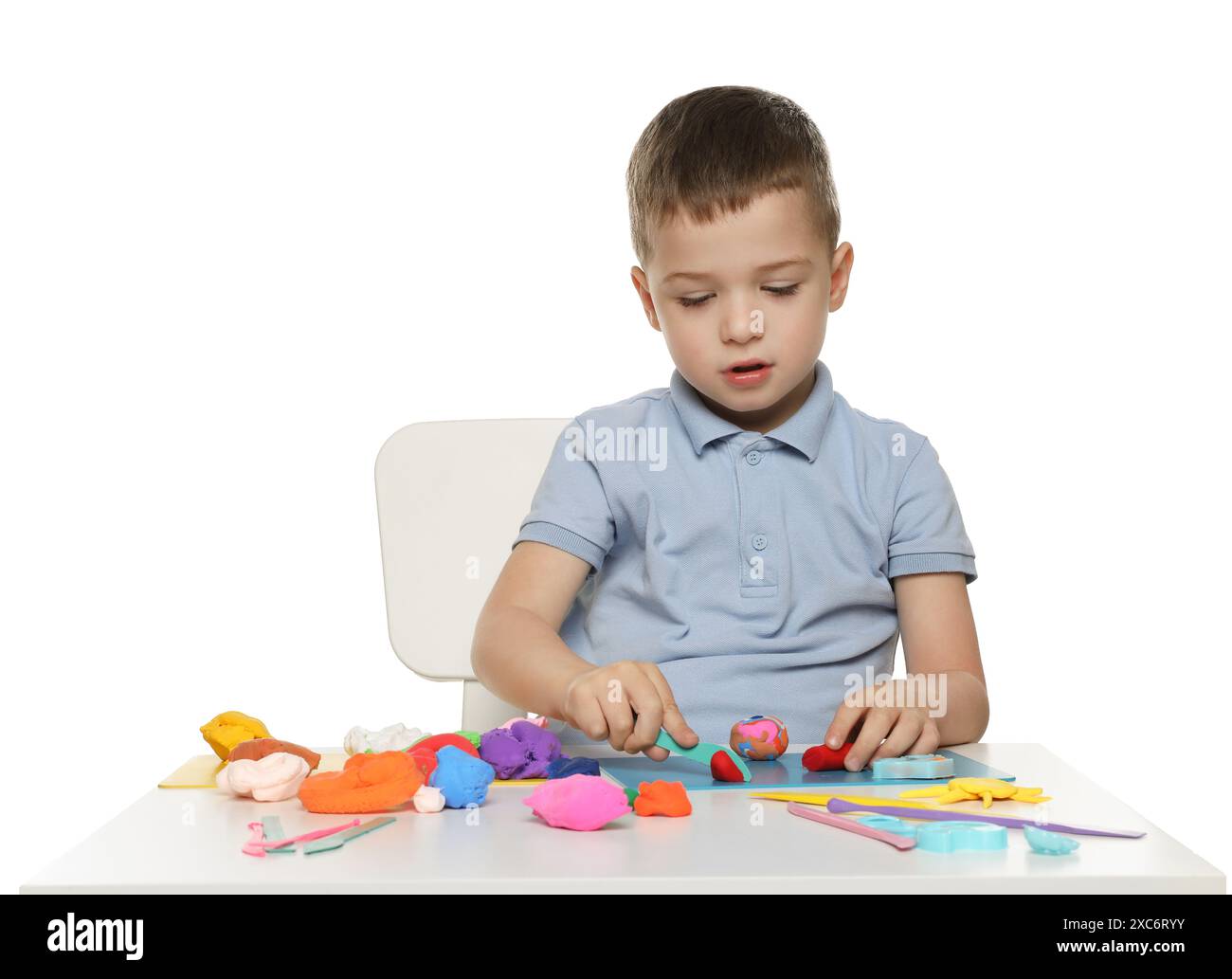 Little boy sculpting with play dough at table on white background Stock ...