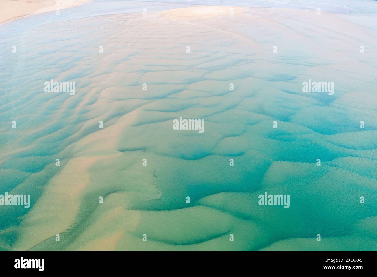 Aerial view of turquoise water flowing over sand ripples in a shallow ...
