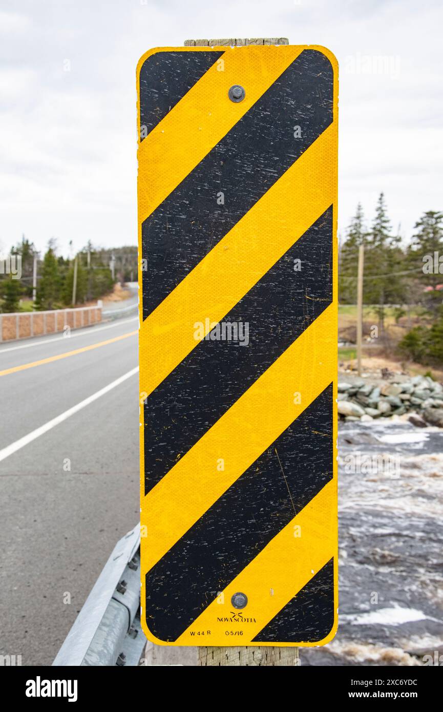 Yellow and black diagonally striped rectangular hazard sign on bridge ...