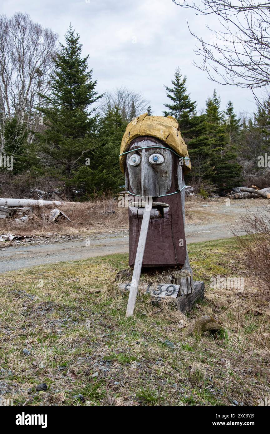 Wooden carving of a fisherman wearing a sou’wester hat in Moser River ...