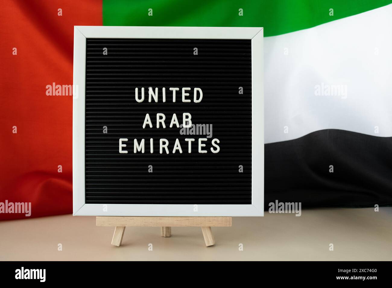 Message UNITED ARAB EMIRATES on background waving flag of UAE. National ...