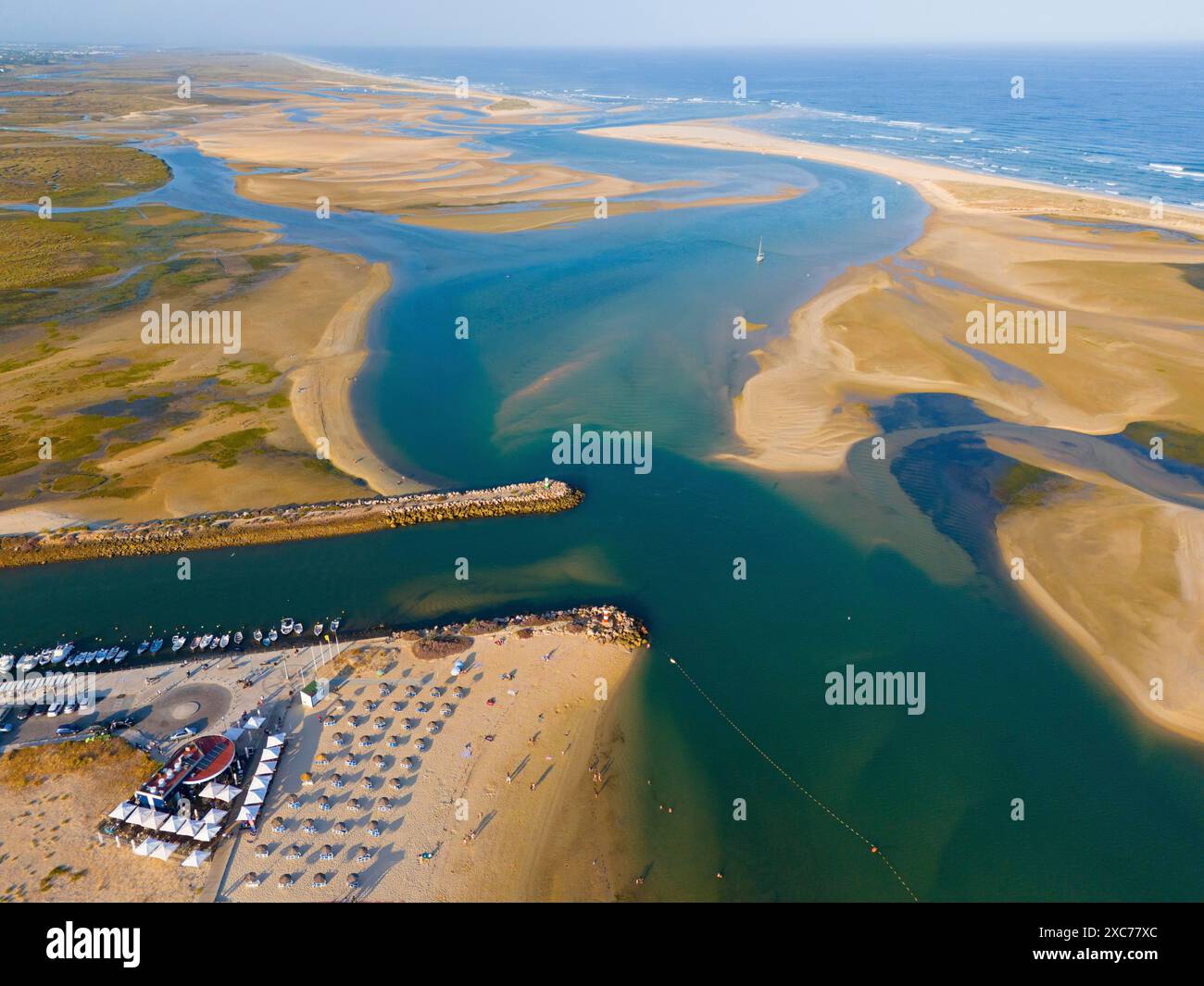 Wide estuary merging into the sea with beaches and boats along the ...