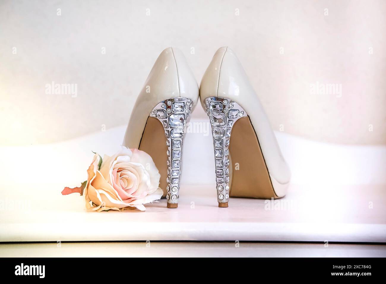 Elegant white high heels with rhinestones, accompanied by a delicate ...