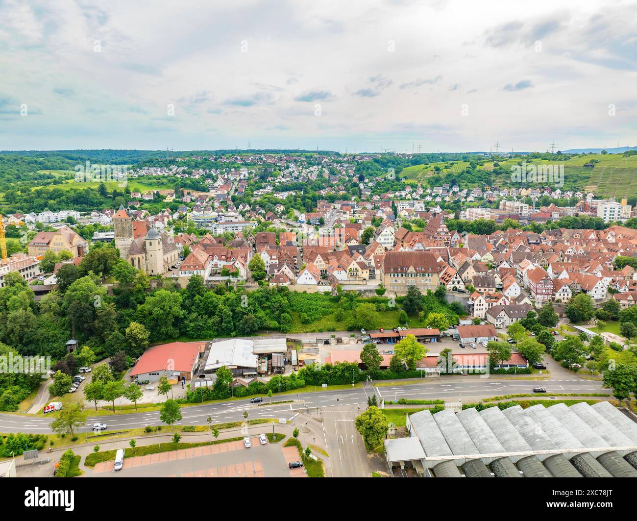 Overview of a town with red tiled roofs, embedded in hilly, green ...