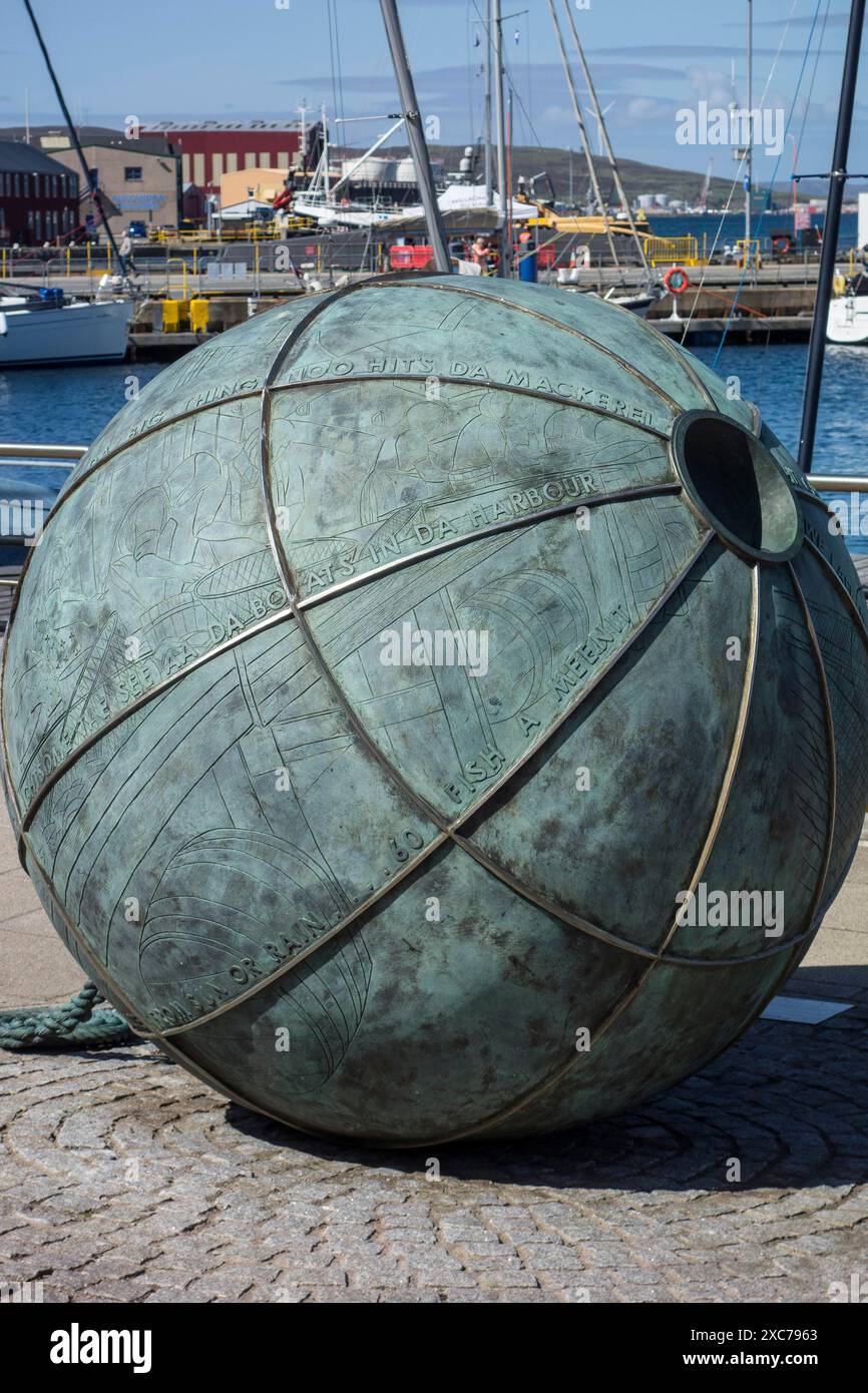 Large spherical sculpture at the harbour, in the background are ships ...