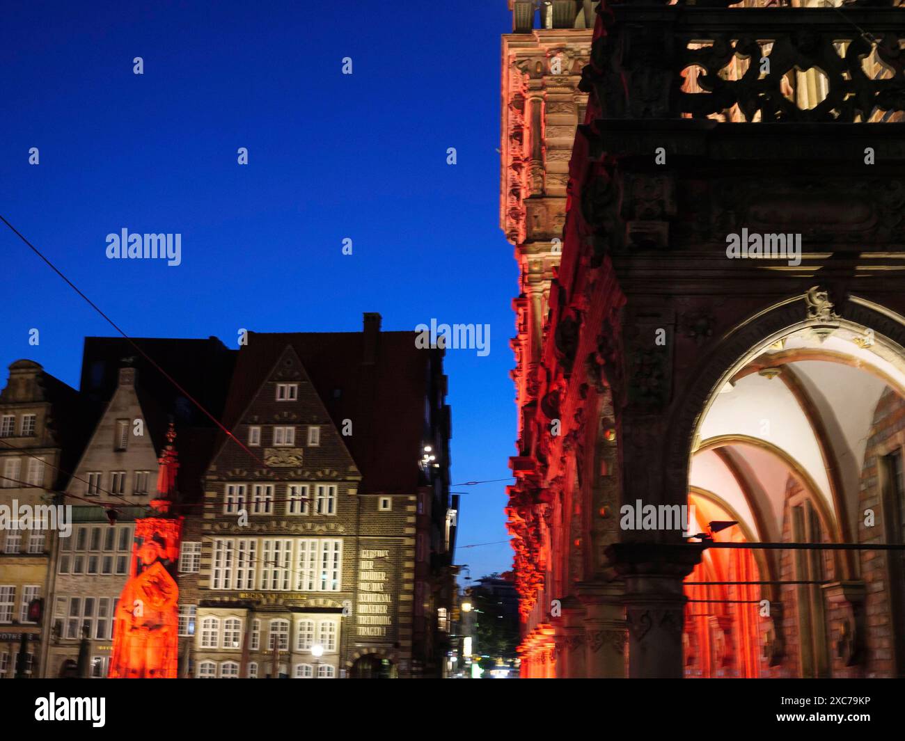 Historic buildings and streets at night, illuminated by red lights and ...